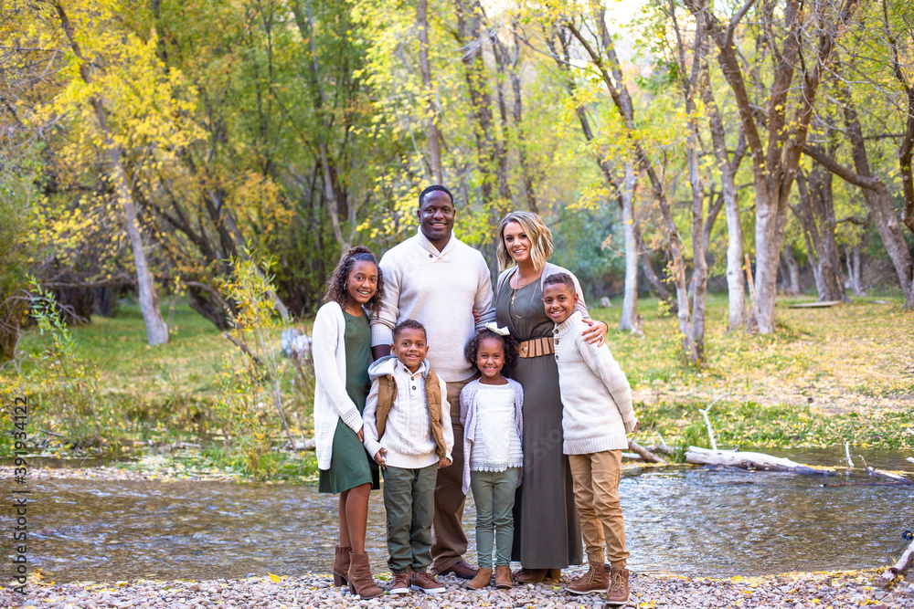 Cute mixed race family portrait outdoors. standing together in nature ...