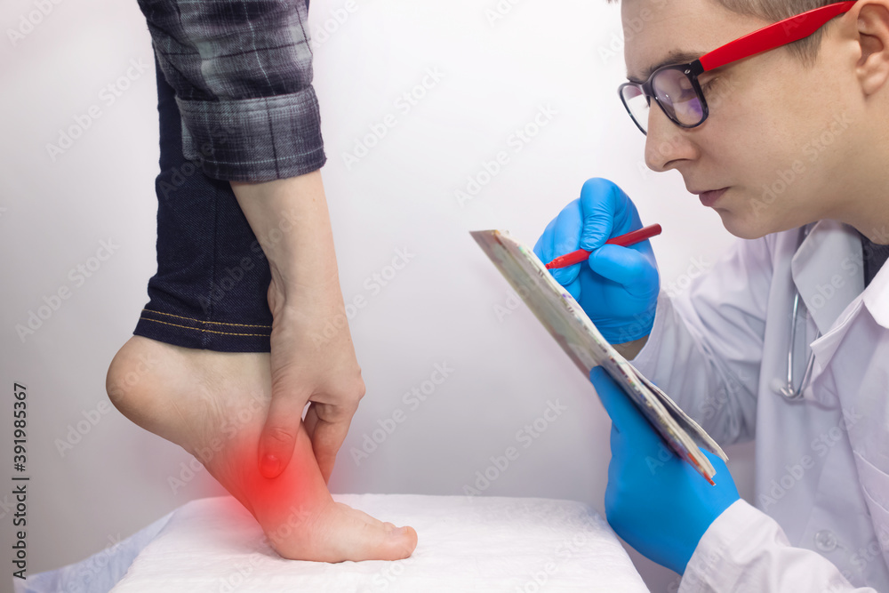 An orthopedic surgeon examines a woman's leg. Foot pain, tendon sprains ...