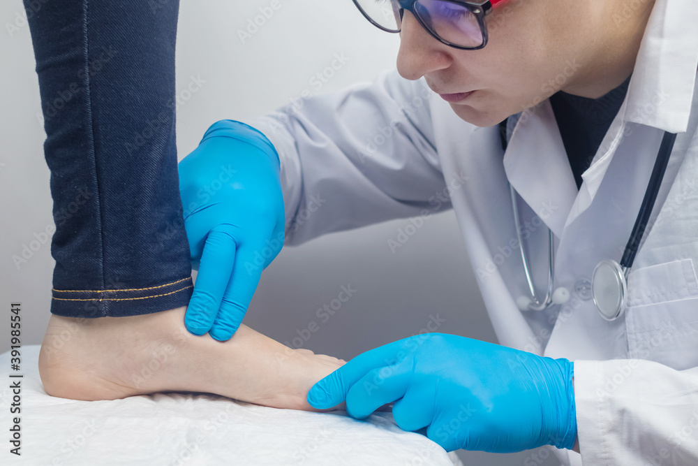 An orthopedic surgeon examines a woman's leg. Foot pain, tendon sprains ...