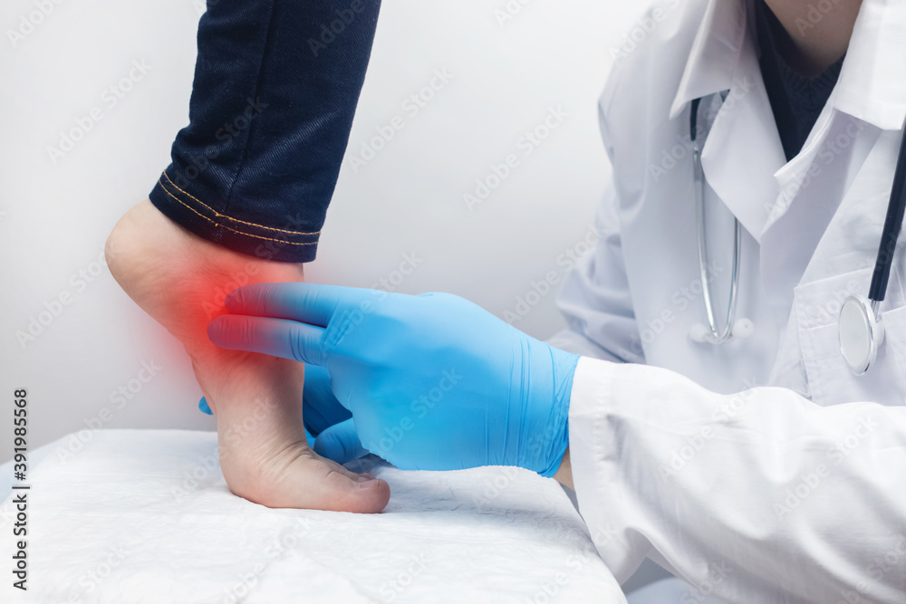 An orthopedic surgeon examines a woman's leg. Foot pain, tendon sprains ...