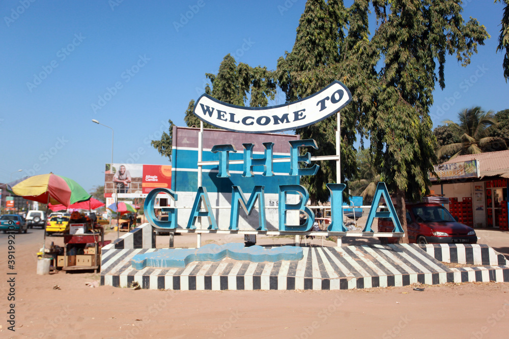 horizontal wide angle photography of a big "welcome to the Gambia" sign ...