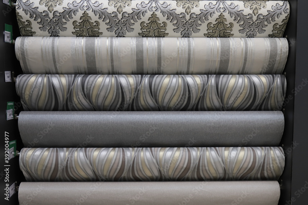 Rolled up rolls of vinyl wallpaper in a building supermarket, shop ...