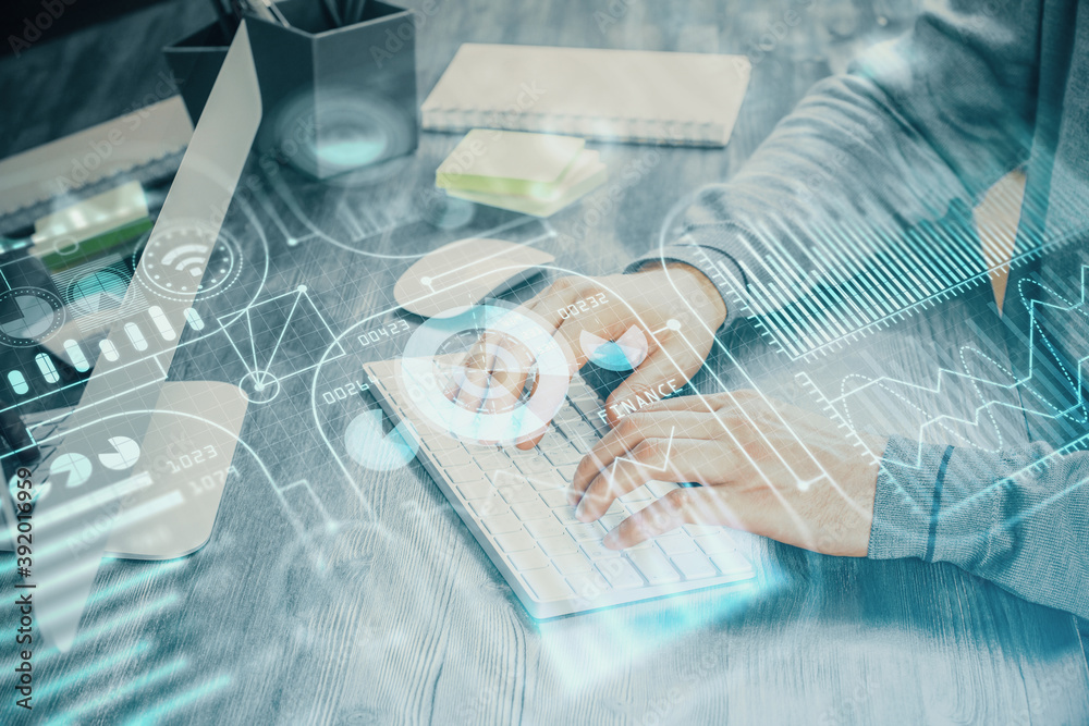 Technology theme hologram with man working on computer on background ...