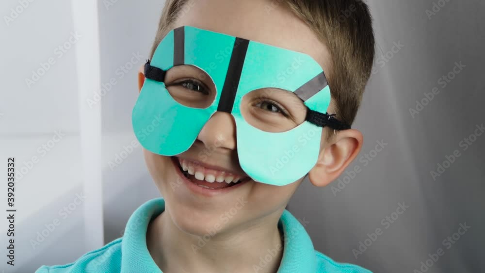 A small boy plays in a room, imagining a hero wearing a comic mask on ...