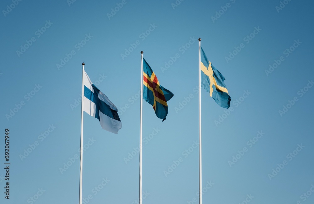 3 skandinavian flags flying together against a blue sky in Finland ...
