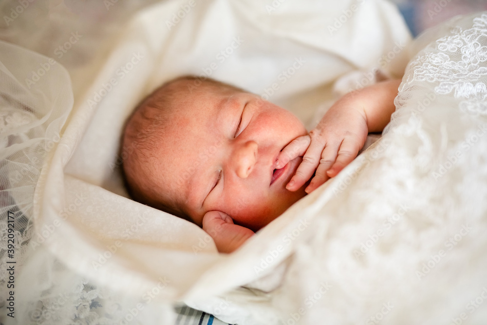Newborn baby boy in bed. New born child in white bodykit lying in light ...