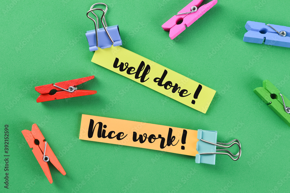 Top view of wooden clips and memo notes written with text WELL DONE ...