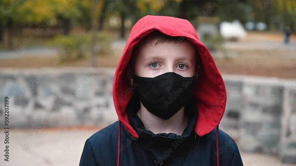 Pandemic, Portrait of little Boy in a red hood wearing medical mask on ...