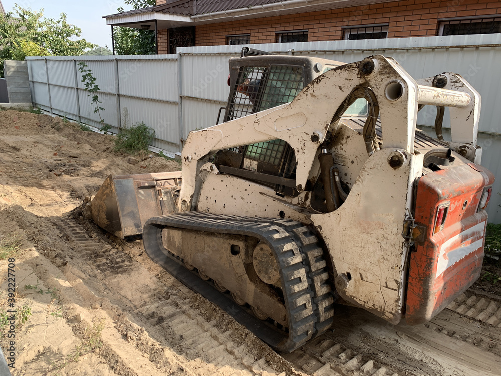 Small tractor with wide bucket. Small construction equipment. The ...