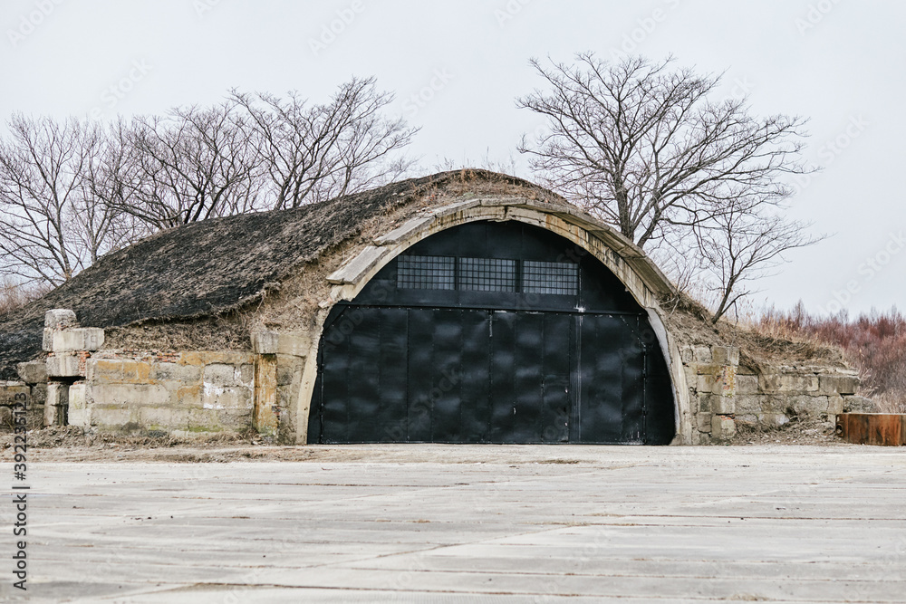 Old military hangar with black metal gates. Vintage concrete USSR ...