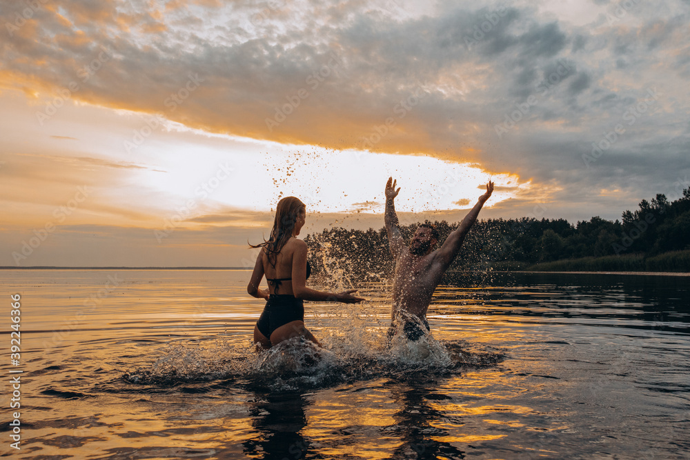 Romantic photo session in the water. A guy and a girl swim in the lake ...