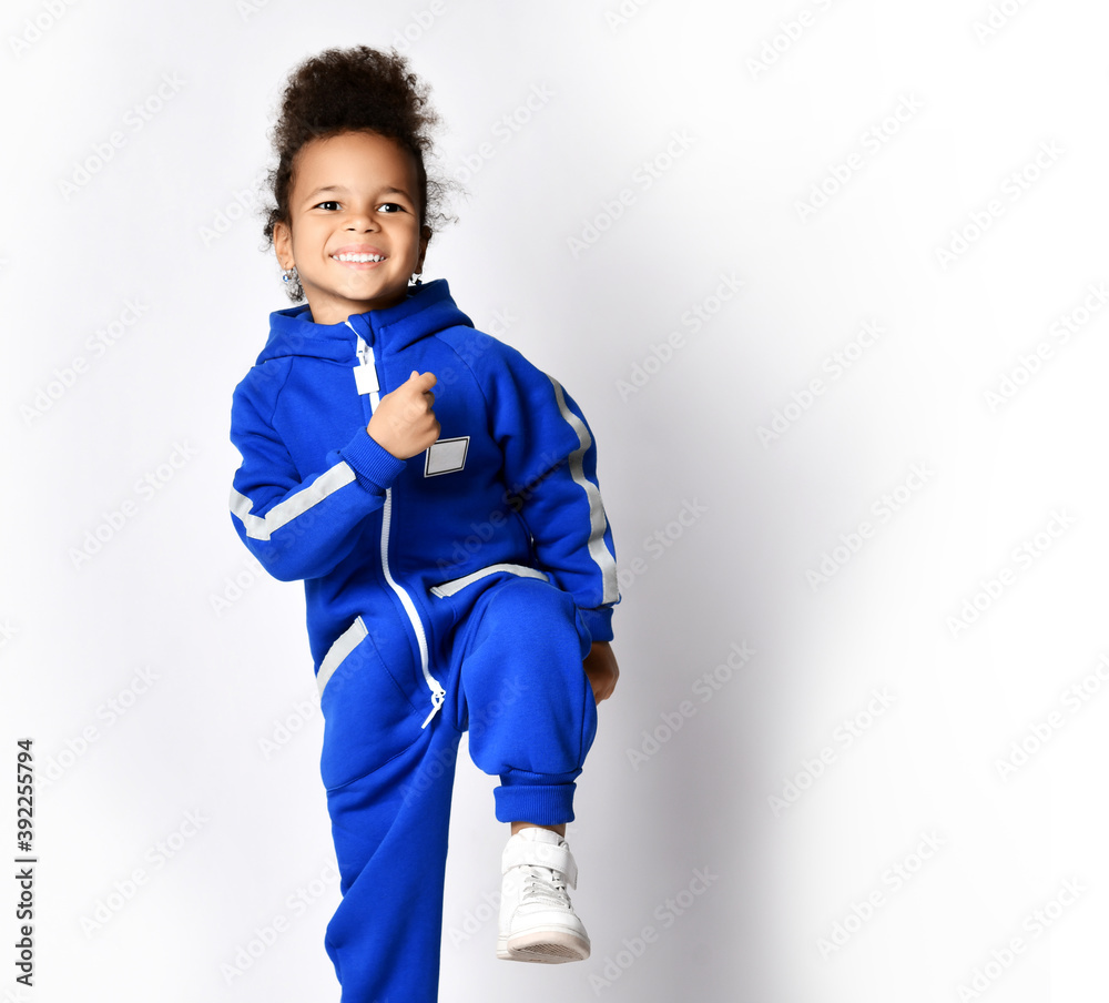 Portrait of frolic smiling dark-skinned afro-russian kid girl in blue ...