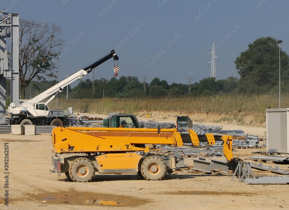 Yellow rotating telehandler work on steel beams in the construction ...