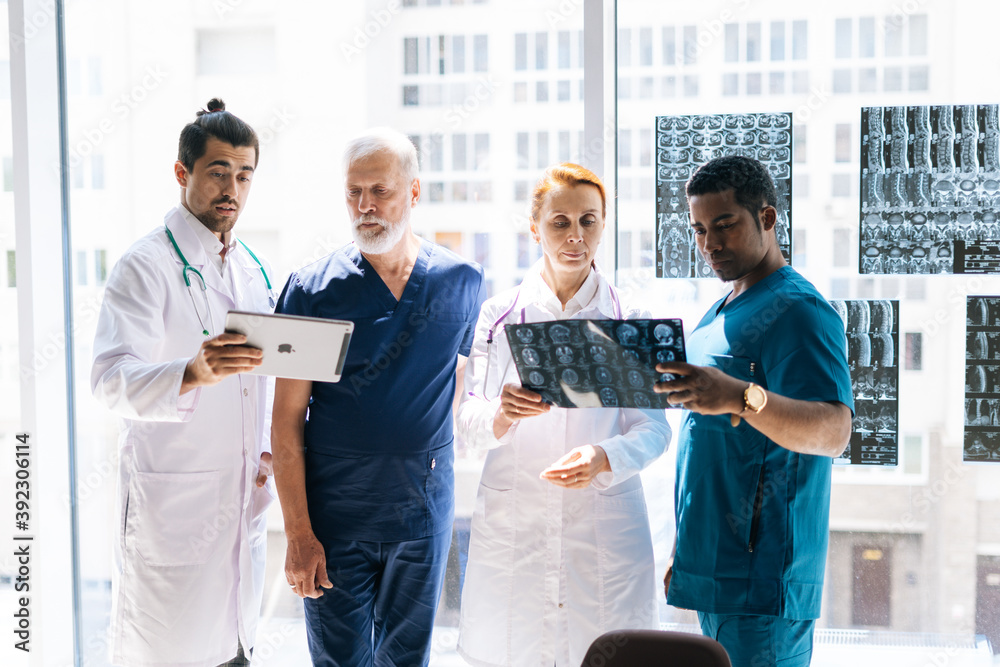 Group of multi-ethnic professional doctors are discussing together ...