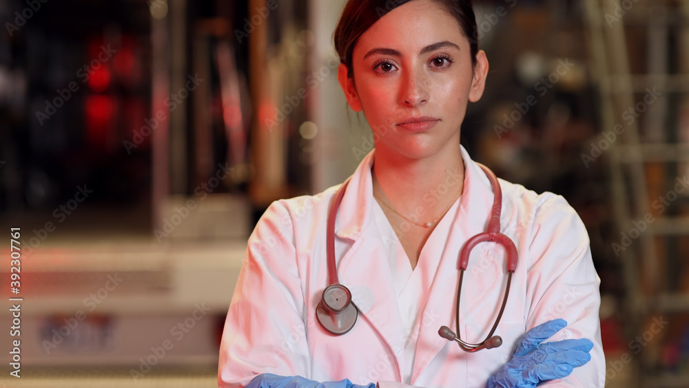 Emergency lights flashing while doctors stands with serious look on ...