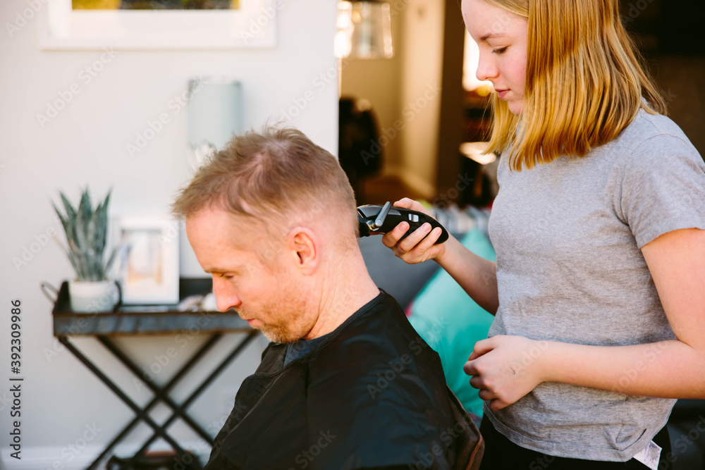 Teenage girl cutting her Dad's hair at home Stock Photo | Adobe Stock