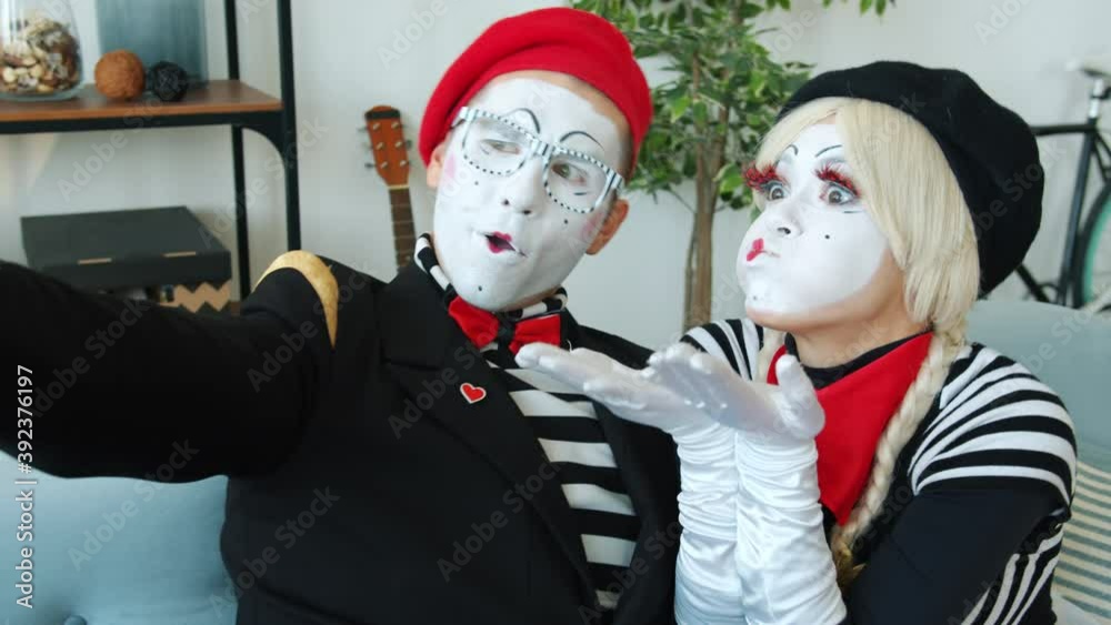 Joyful couple of mimes funny girl and guy are taking selfie with ...