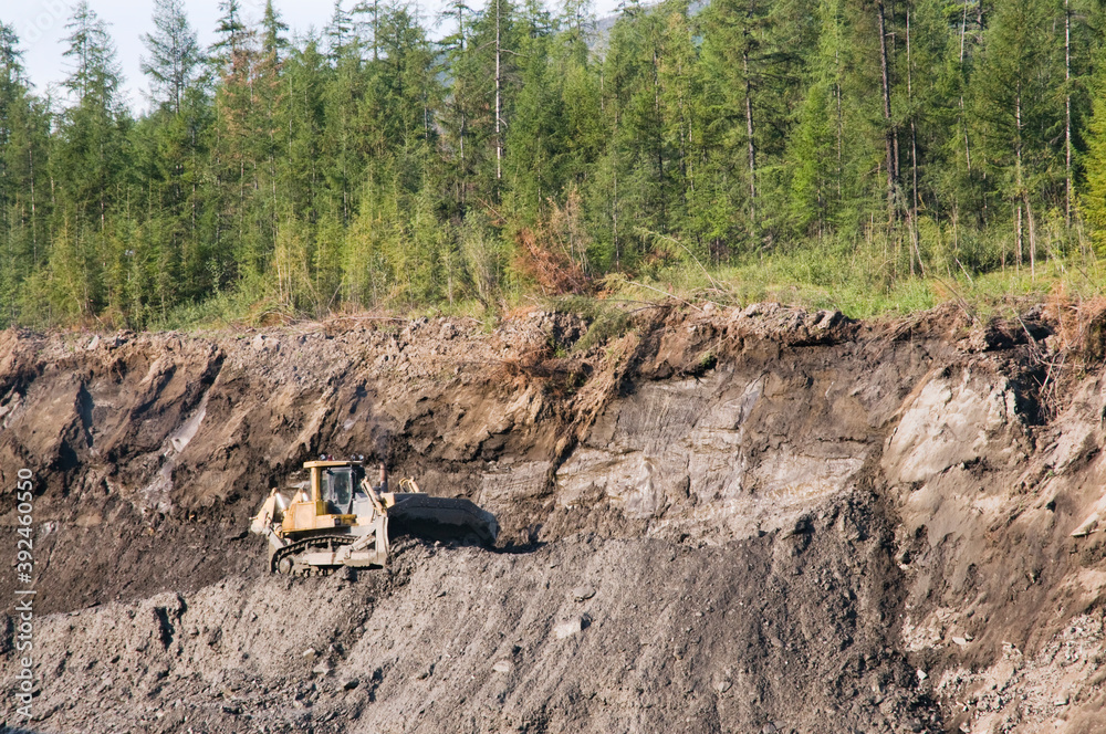 Bulldozers at work. Mining. Bulldozers cut the topsoil in a mountainous ...
