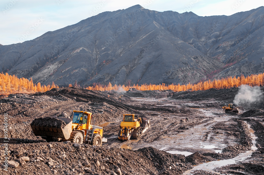 Bulldozers and wheel loaders at work. Mining. Bulldozers cut the ...