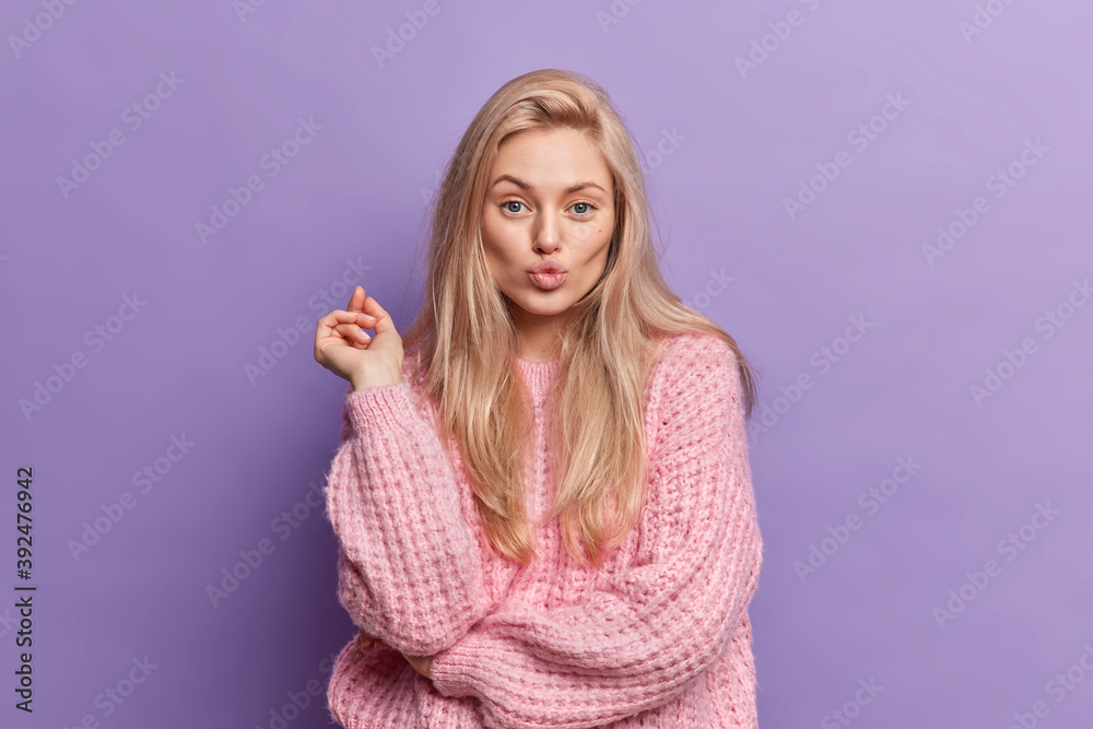 Blonde confident feminine woman looks with flirty expression at camera ...