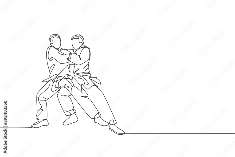 One continuous line drawing of two young sporty men training judo ...
