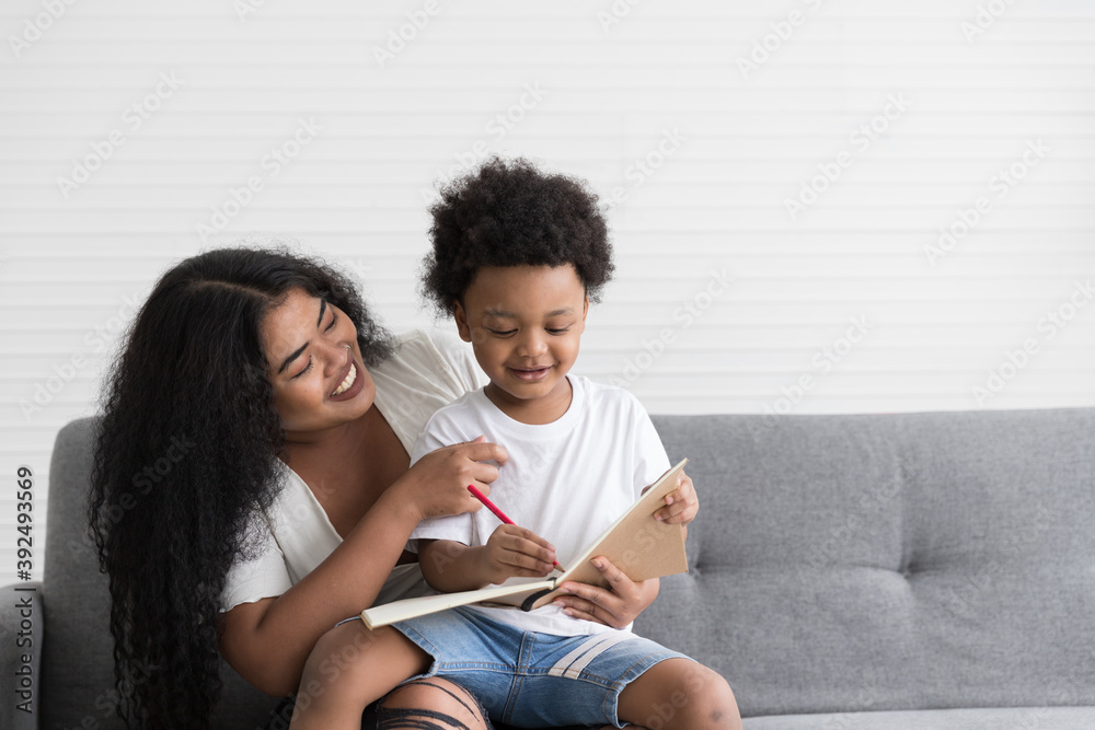 Happy African American family sitting on sofa at home. Smiling African ...