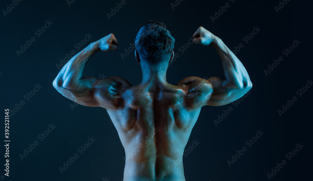 Model sports young man on dark background. Sporty muscle guy showing ...