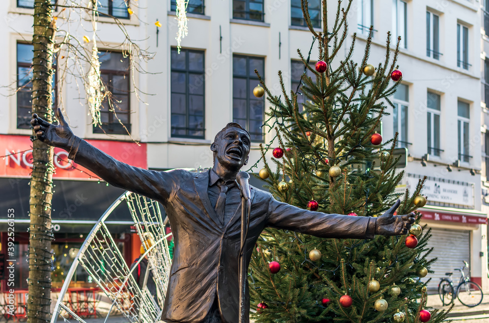 Statue of Jacques Brel and Christmas tree. Bronze statue entitled L ...