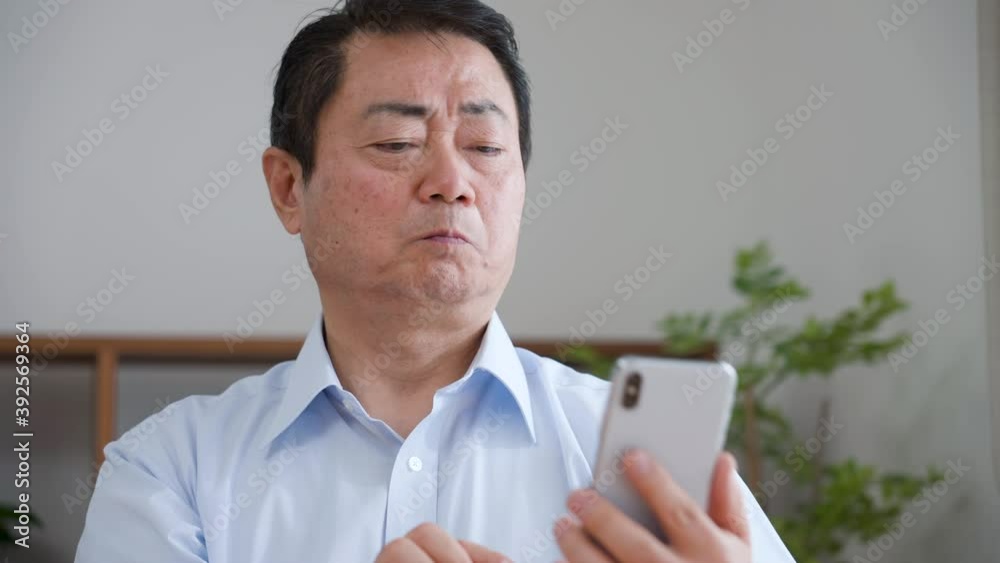 Vidéo Stock スマートフォンを使う老眼の中年男性 Adobe Stock