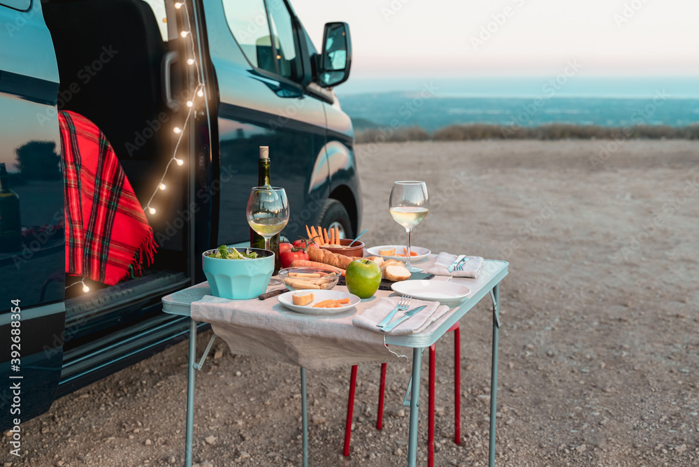 Healthy vegan picnic celebration in camper van with landscape in ...