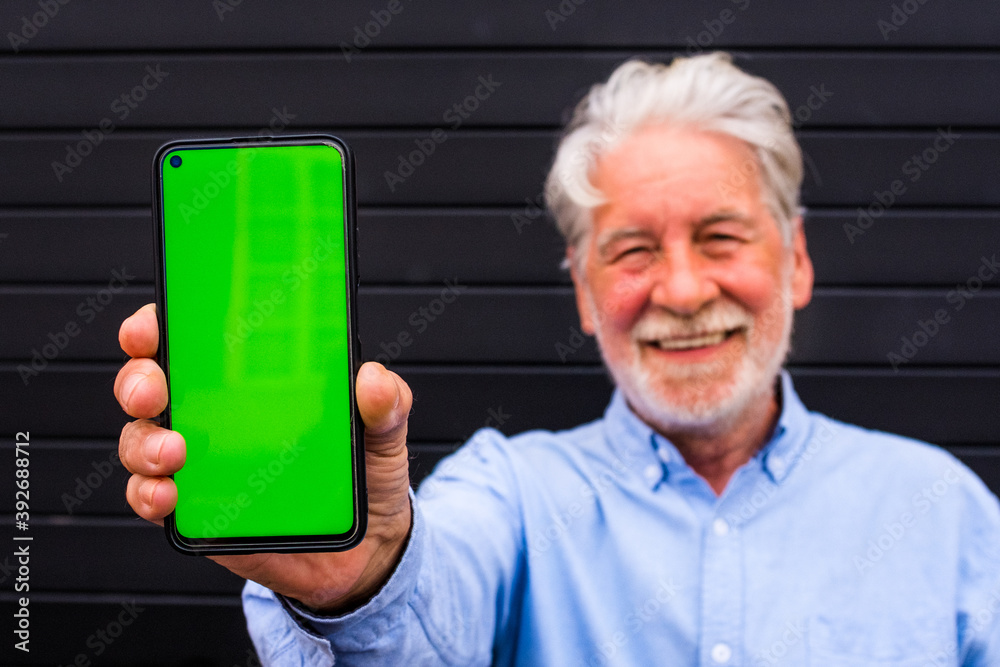 one old and mature senior man holding a mobile phone with green screen ...