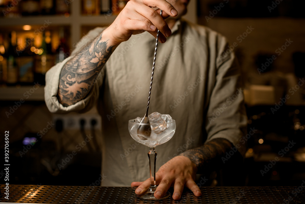 bartender with long bar spoon stir the ice cubes in wine glass Stock ...