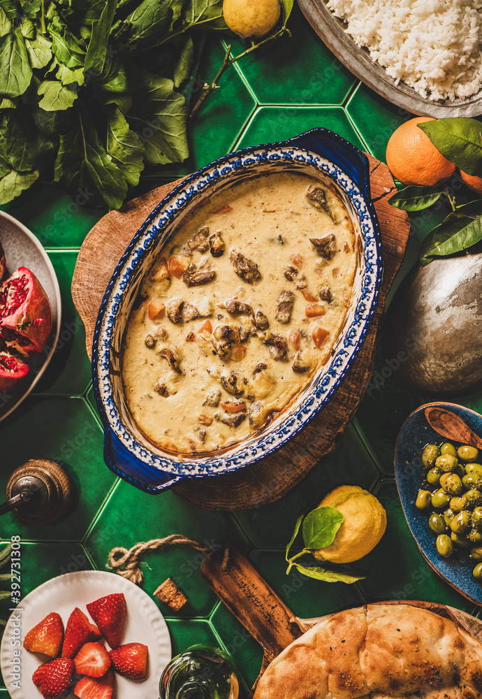 Turkish style family dinner. Flat-lay of lamb in yogurt sauce and ...