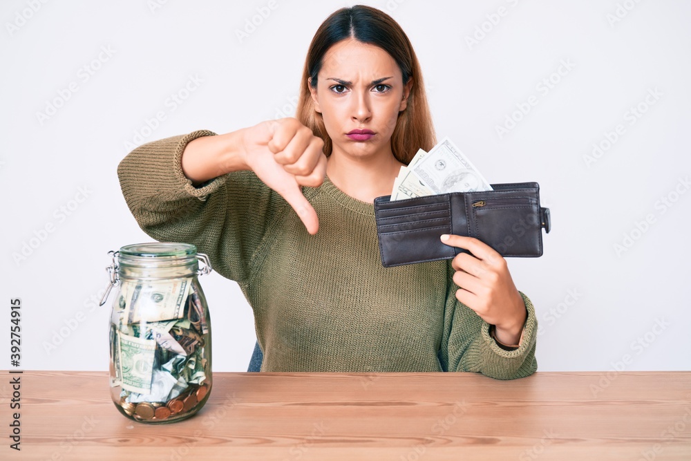 Young brunette woman with savings jar and wallet with dollars with ...