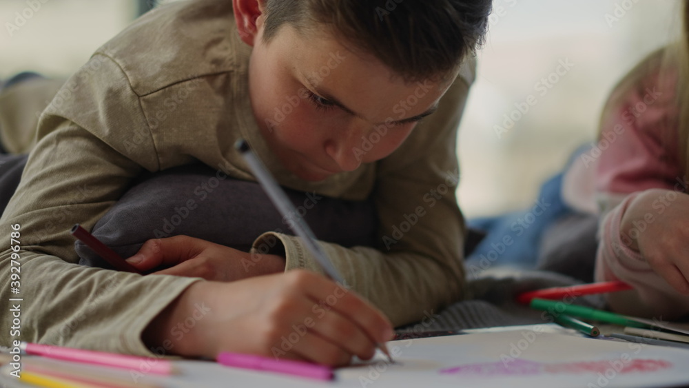 Cute boy coloring picture with pencils. Brother drawing next to sister ...