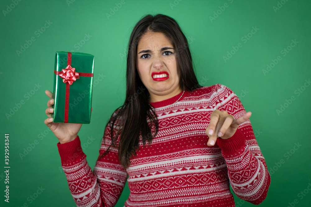 Young beautiful girl holding gift over isolated white background ...