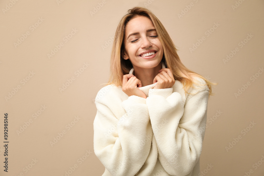 Beautiful young woman wearing knitted sweater on beige background Stock ...