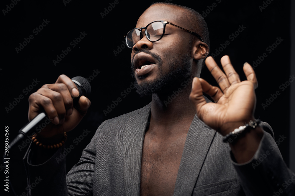 portrait of a dark-skinned handsome guy in grey jacket and glasses on a ...