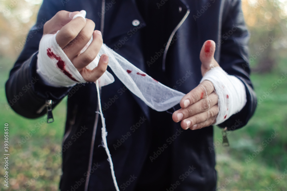 Man with bandage with blood on the knuckles, natural background. End of ...