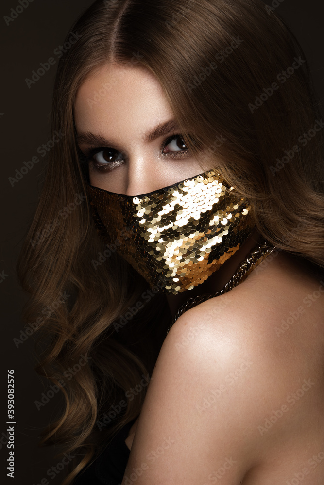 Portrait of a beautiful woman in a gold mask with sequins and classic ...