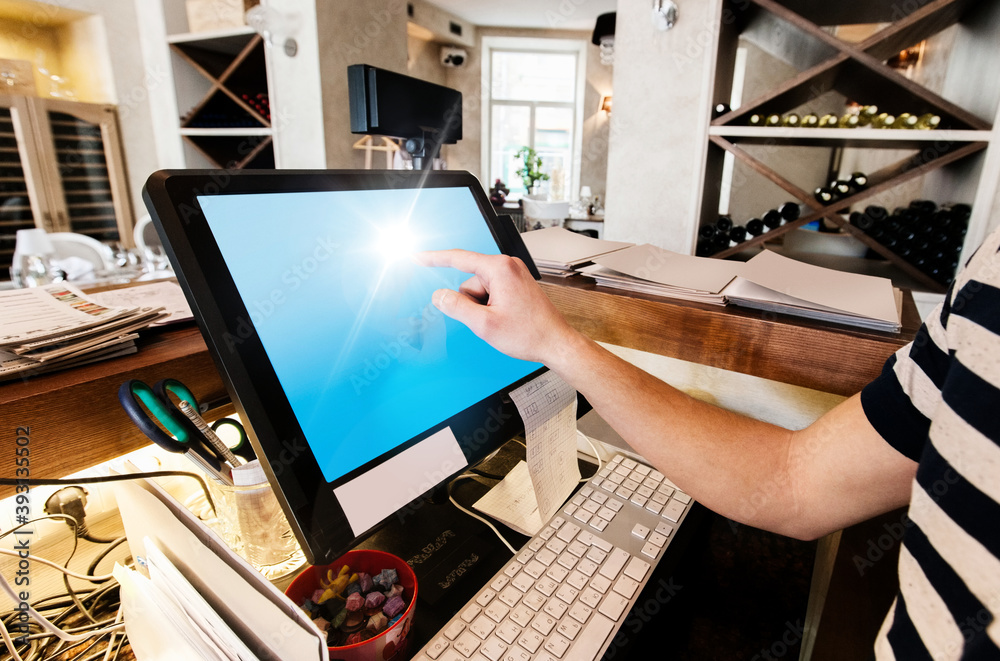 Cropped image of cashier touching computer screen at restaurant counter ...