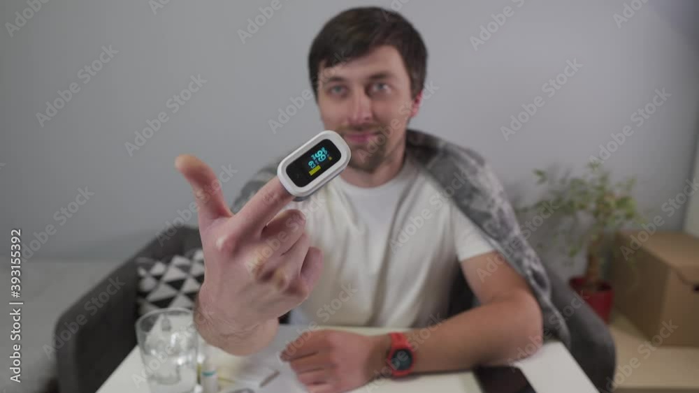 Measuring Oxygen Saturation in Blood with Pulse Oximeter. Young man at ...