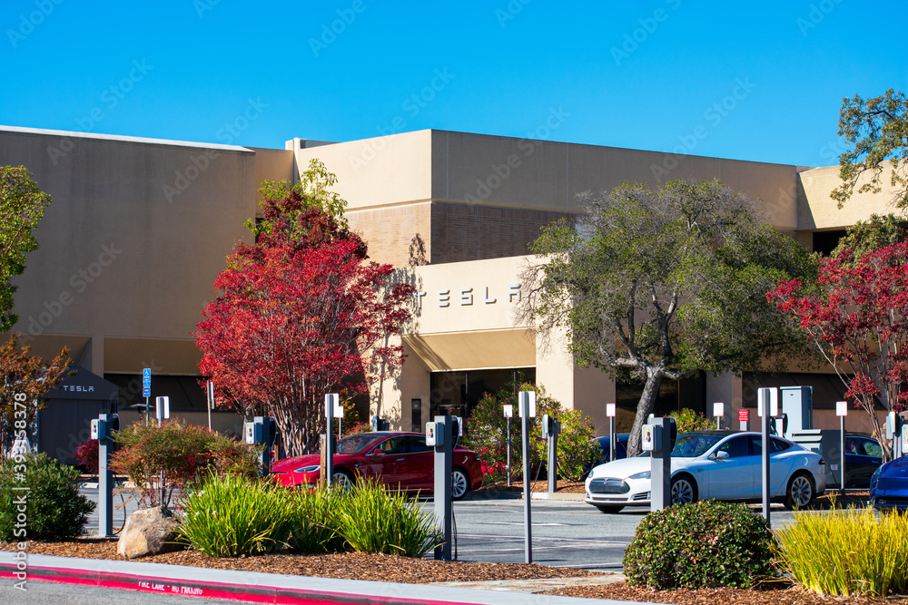 Tesla headquarters exterior with several Tesla electric cars parked in ...