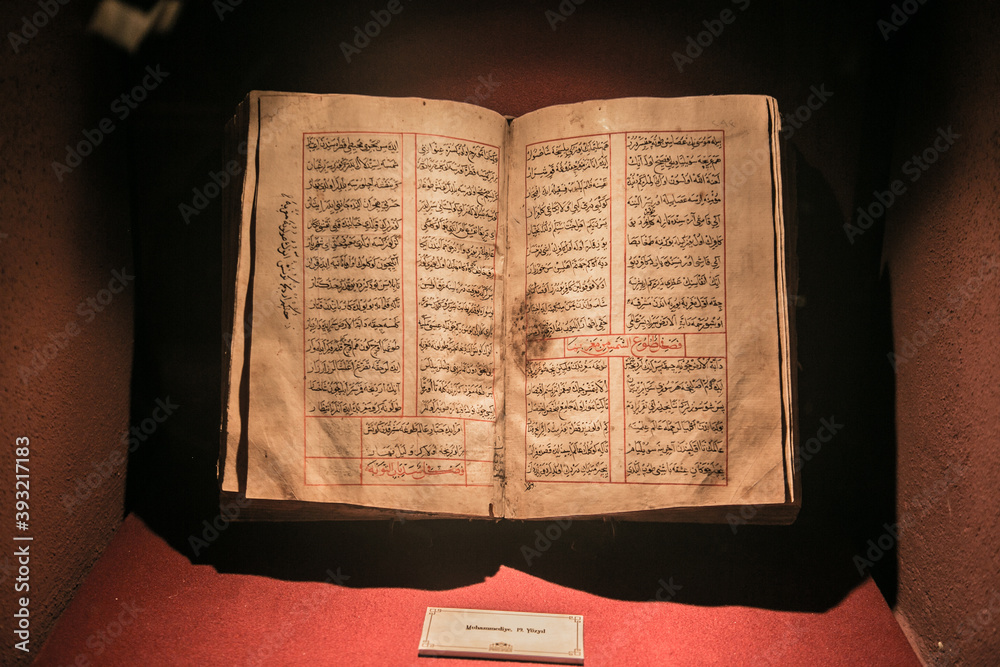 Old ancient quran (islam holy book) on red light. hand written Koran ...
