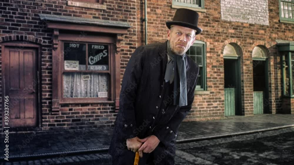 Ebeneezer Scrooge is standing in a Victorian street, waving his cane ...