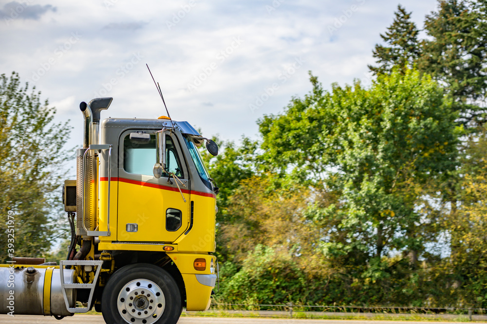Big rig cab over yellow semi truck tractor running on the road with ...