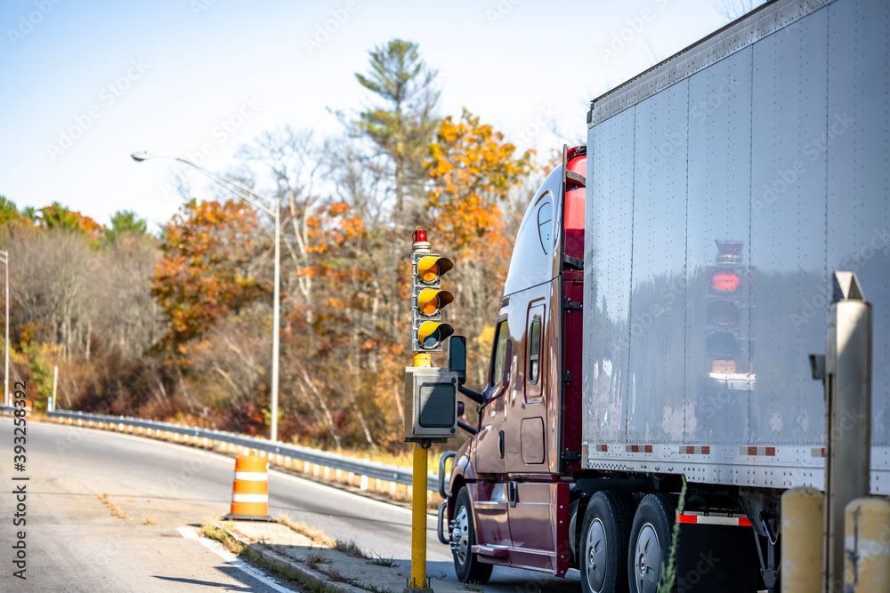 Red big rig shiny semi truck with dry van semi trailer standing on the ...