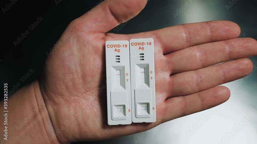 Close up of a positive test for coronavirus in a man's hand. Two tests ...