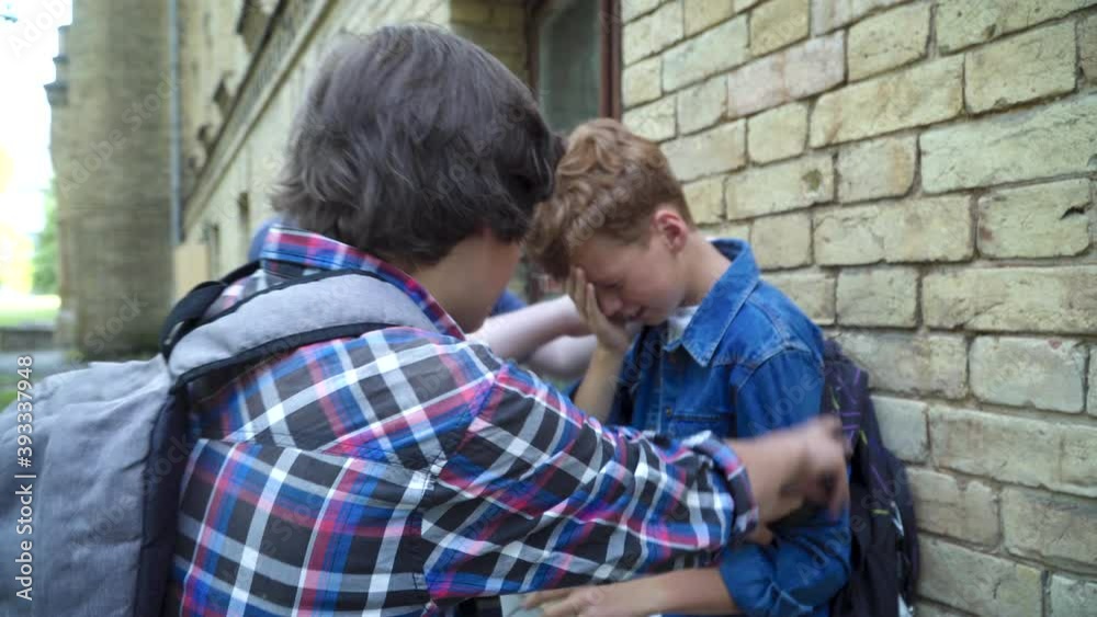Aggressive classmates bullying frightened redhead nerd on schoolyard ...