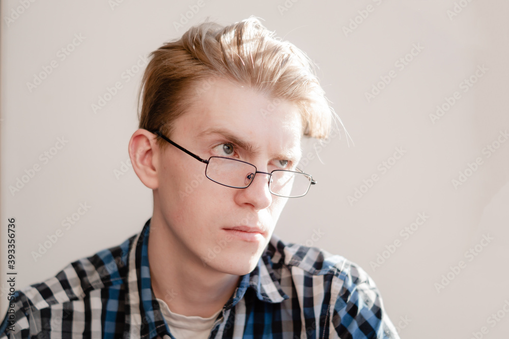 a man frowning his face looks with suspicion, a portrait with glasses ...